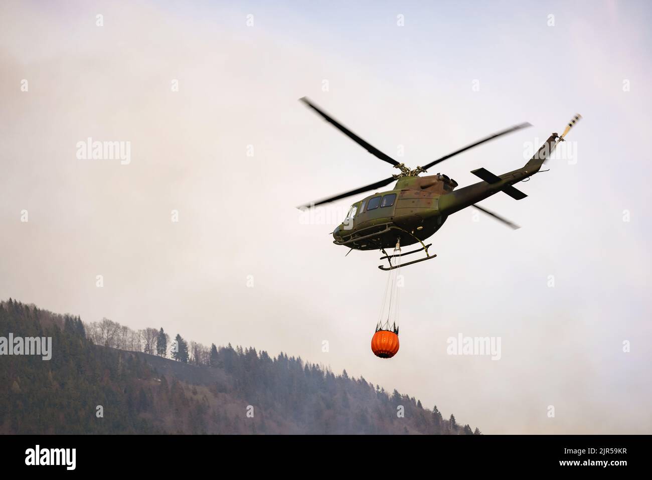 Localized wildfire with the helicopter dropping water by using a water ...