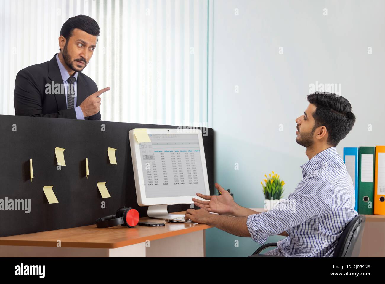 An angry boss in formal business suit scolding junior corporate ...