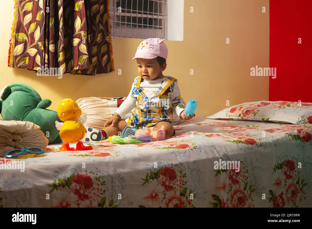 Portrait of little child playing with toys on bed Stock Photo - Alamy