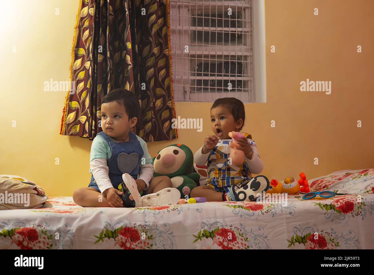 Portrait of two little babies playing on bedroom Stock Photo - Alamy