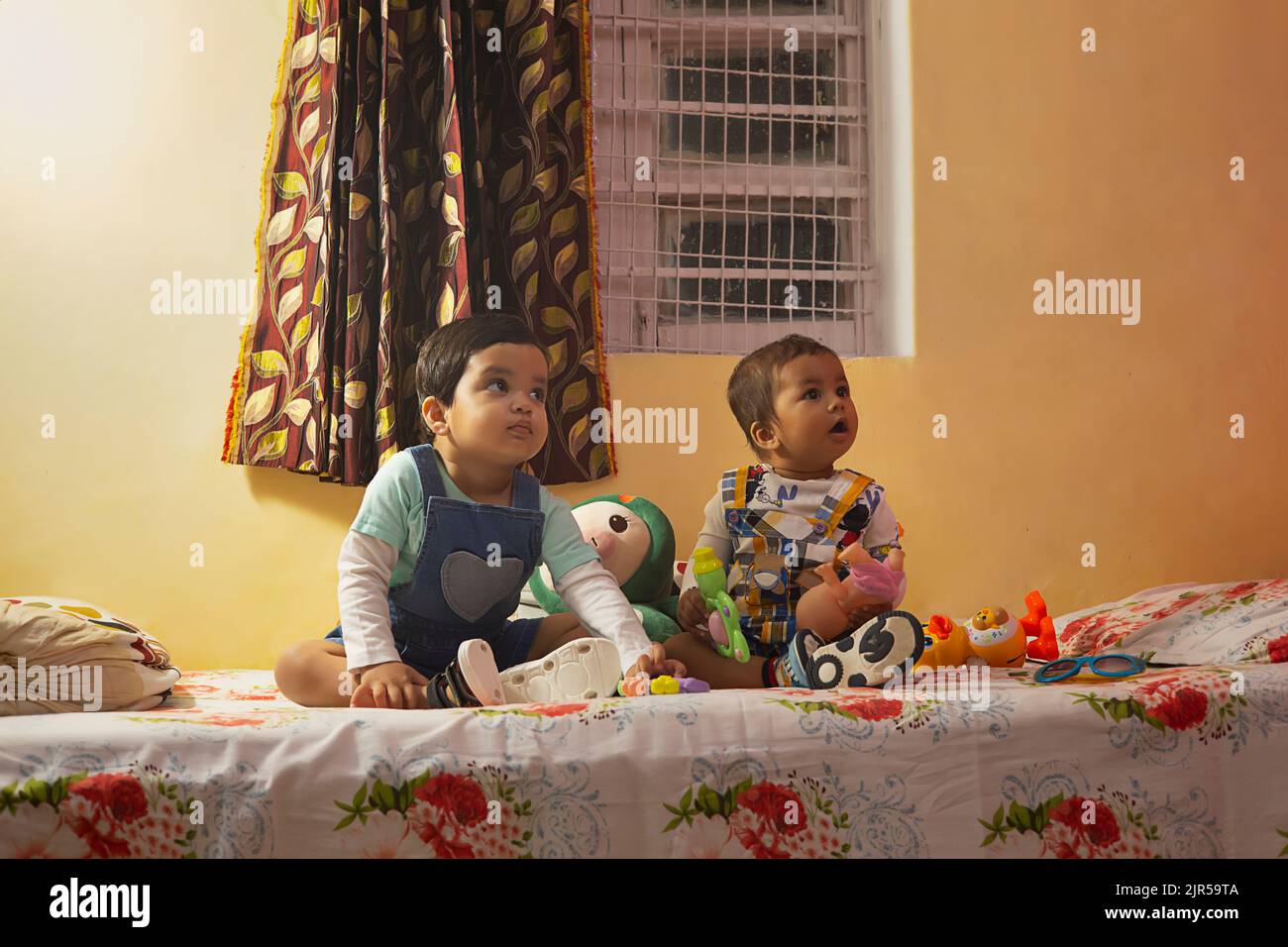 Portrait of two little babies playing on bedroom Stock Photo - Alamy