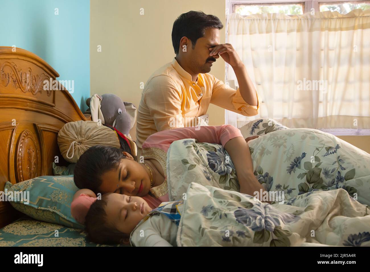 Father waking up in the morning while mother and baby sleeping on bed ...