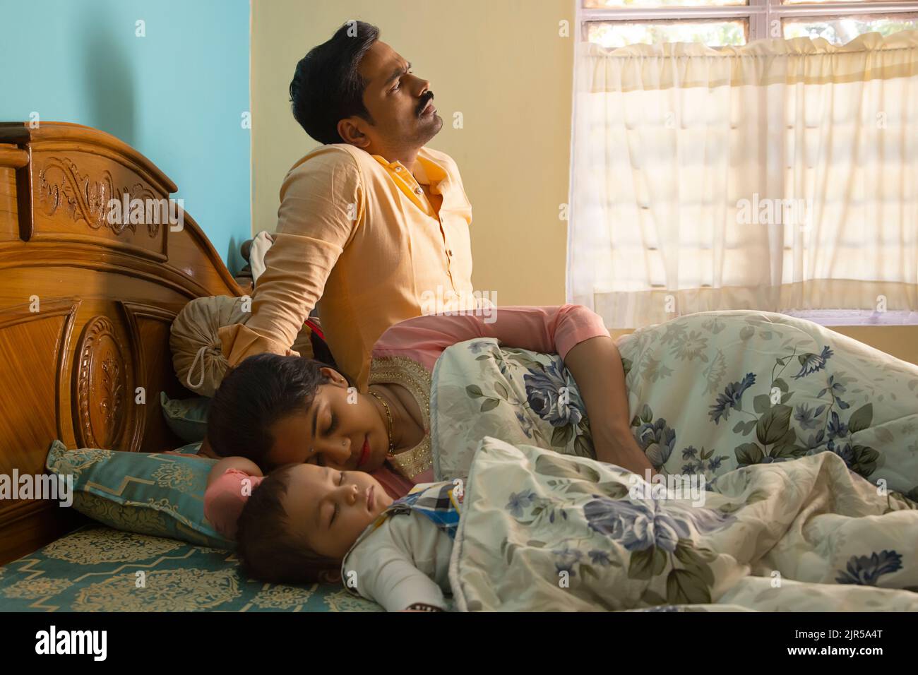 Father waking up in the morning while mother and baby sleeping on bed ...