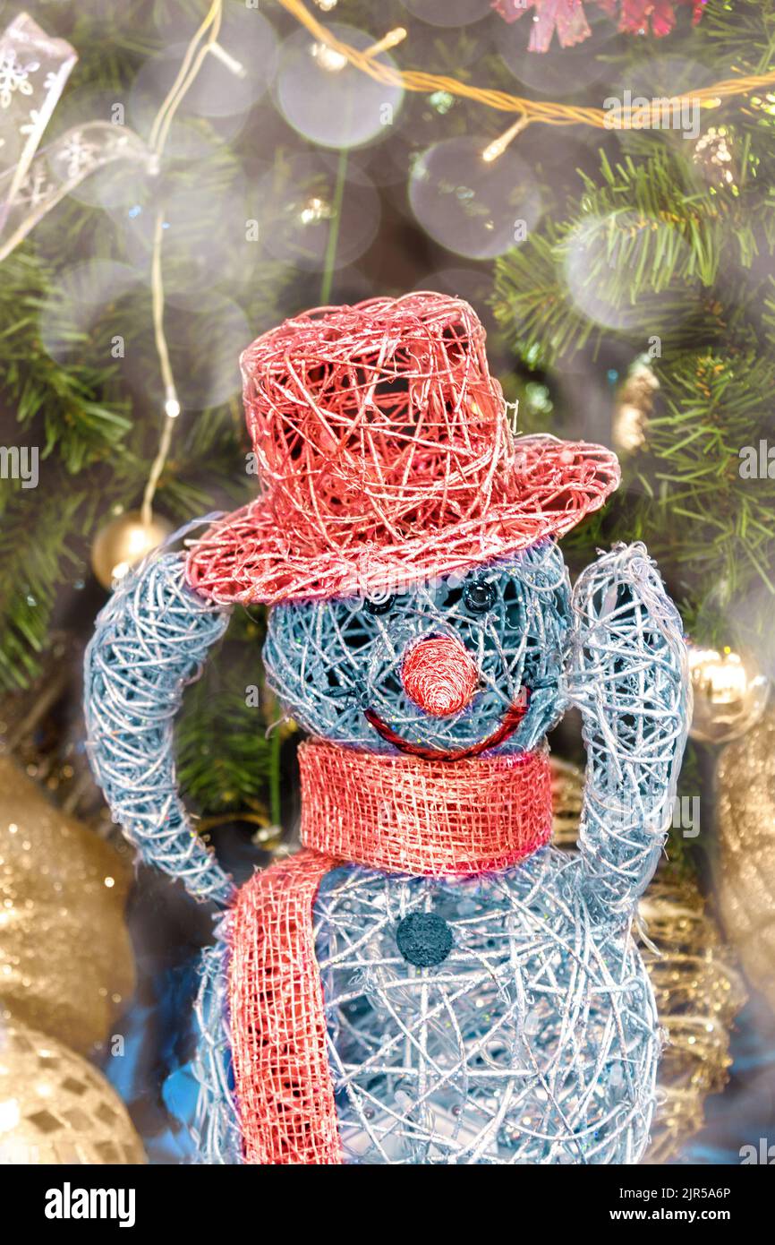 A snowman figurine in a hat and scarf made of garlands and garlands ...