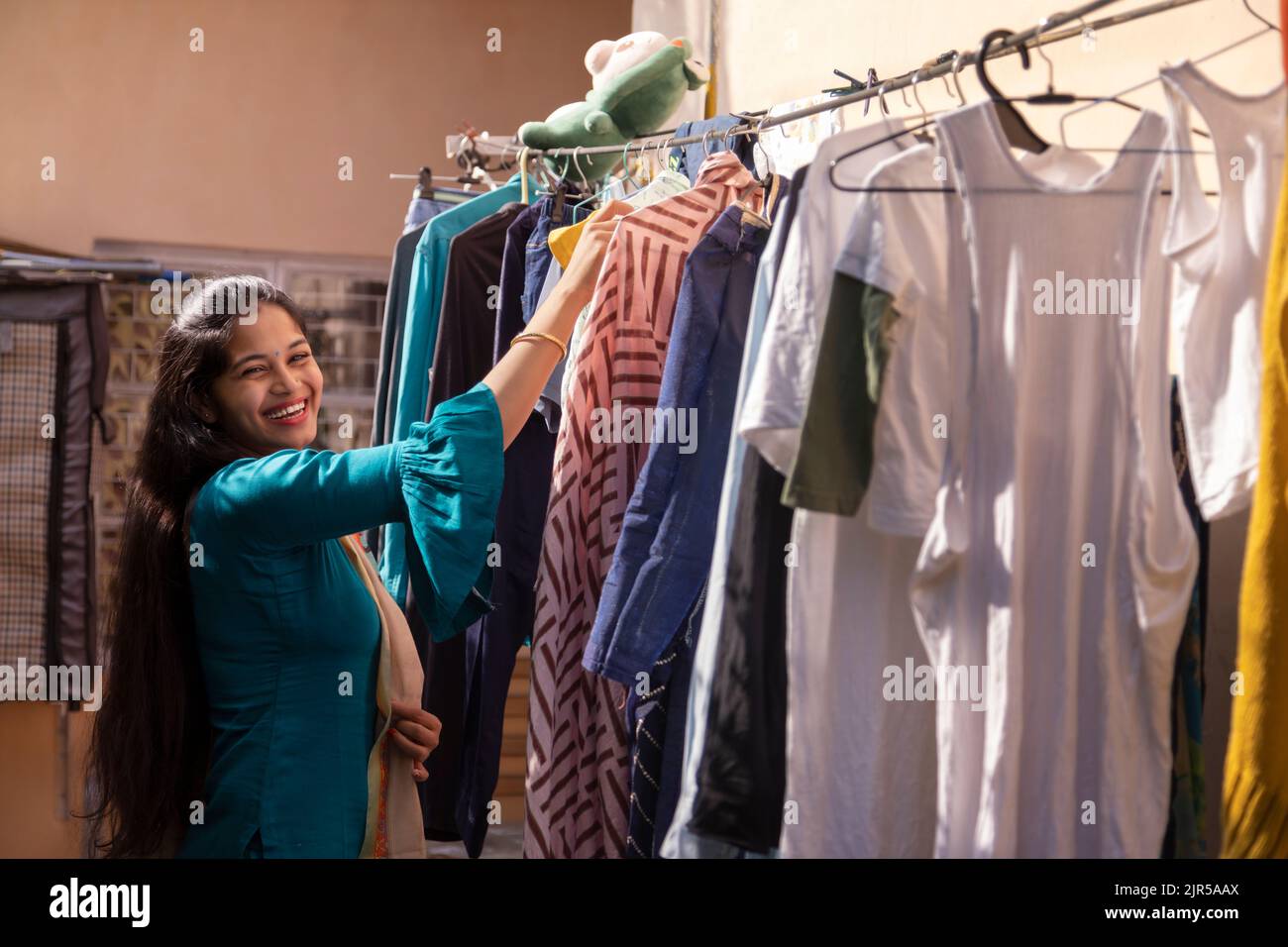 Young woman hanging clothes on washing line to dry outside Stock Photo ...