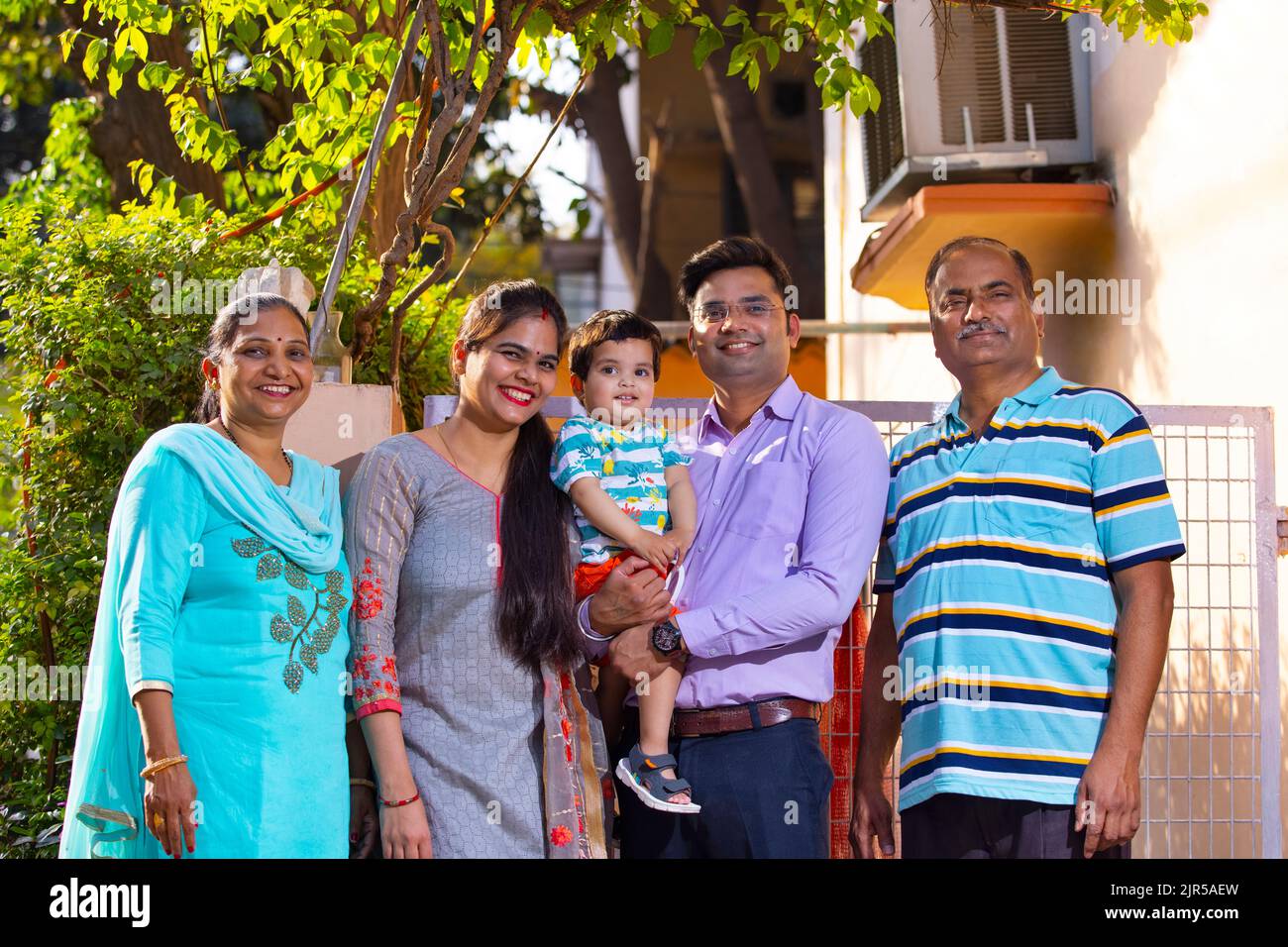 Portrait of happy family members standing in front of gate Stock Photo ...