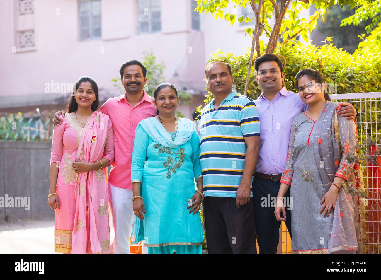 Portrait of happy family members standing in front of gate Stock Photo ...