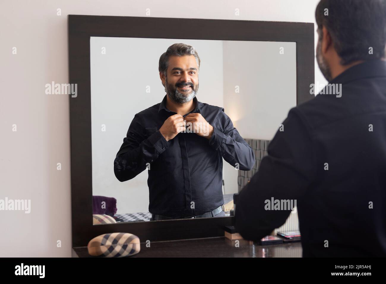 Portrait of a man dressing in front of mirror at home Stock Photo - Alamy