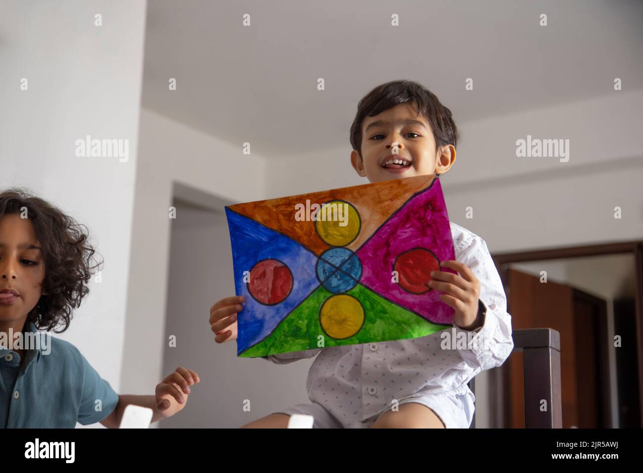 Portrait of a little child holding up a colourful painting Stock Photo ...