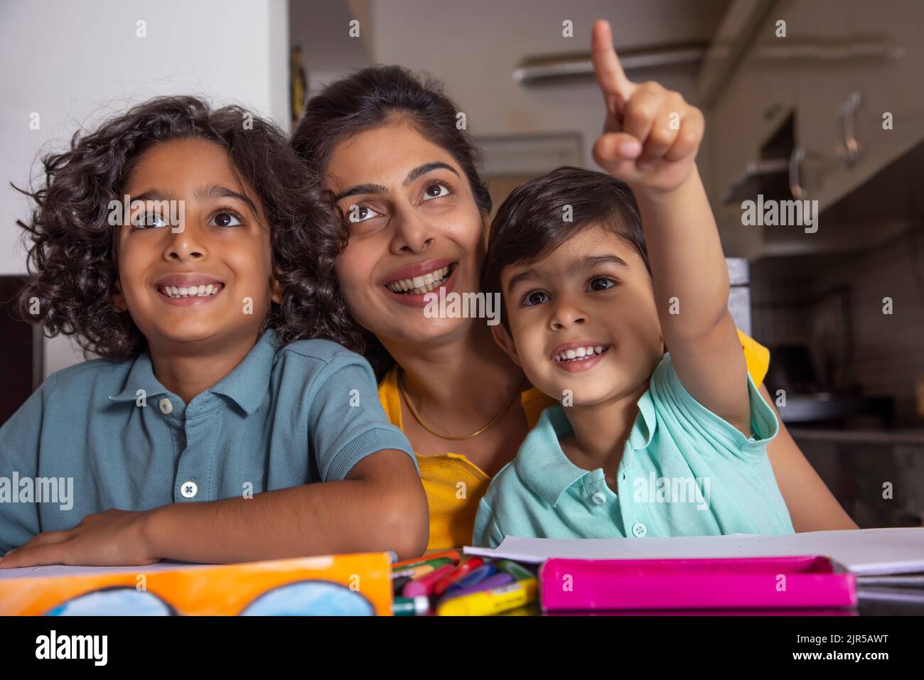 Mother with her children looking above during painting Stock Photo - Alamy