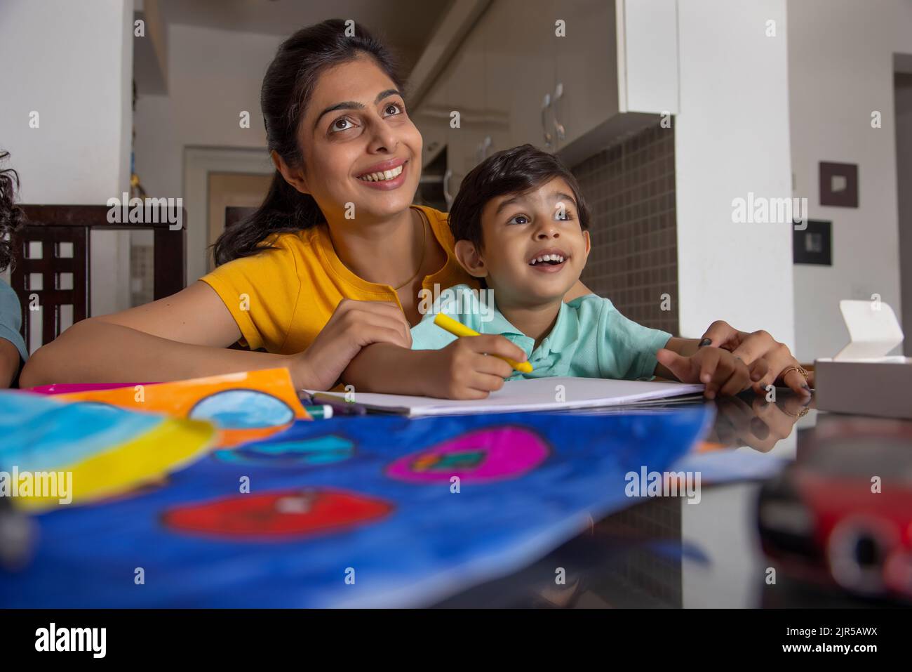 Mother and son looking above during painting Stock Photo - Alamy