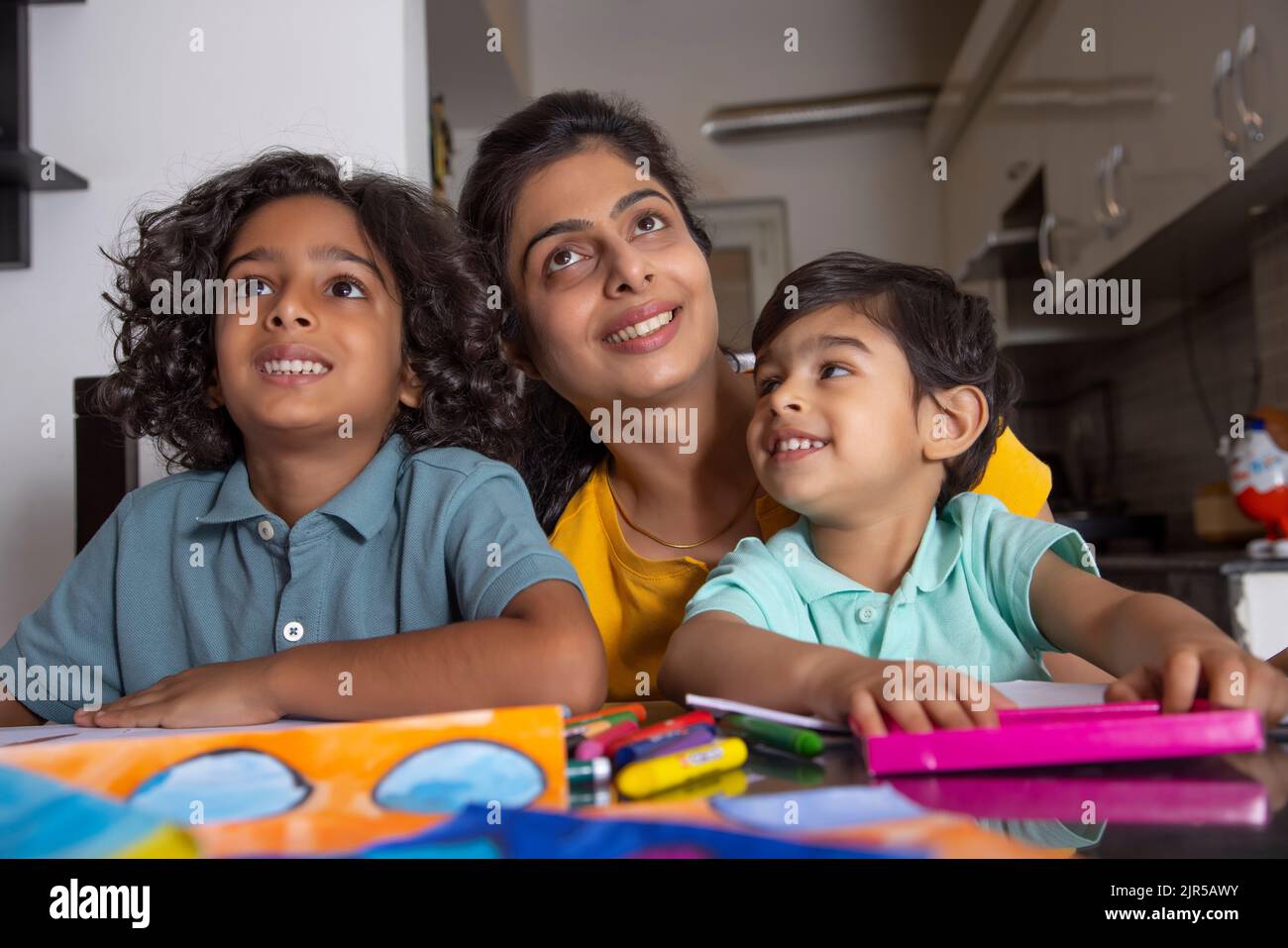 Mother with her children looking above during painting Stock Photo - Alamy