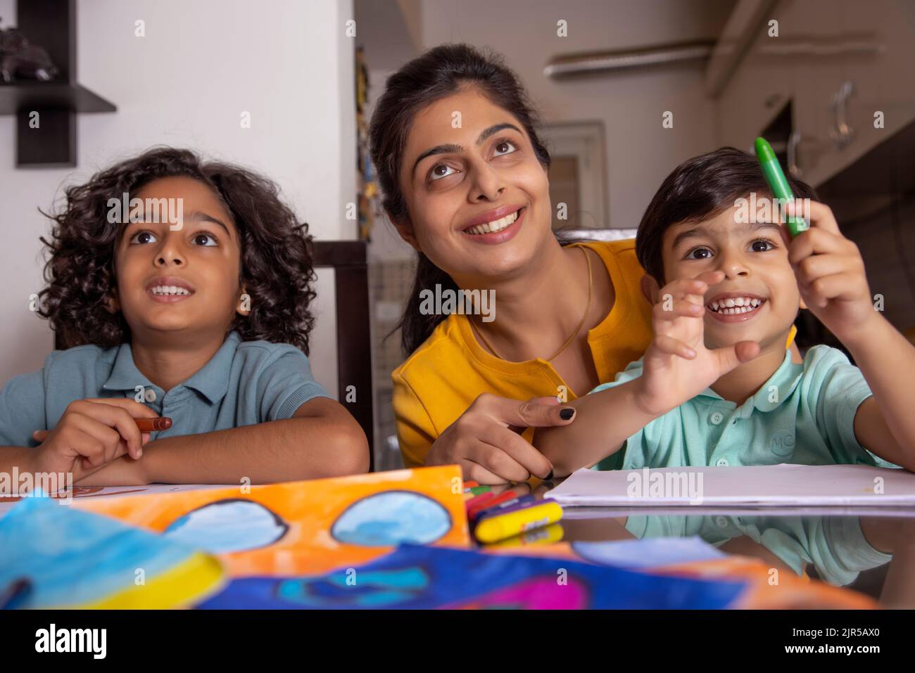 Mother with her children looking above during painting Stock Photo - Alamy