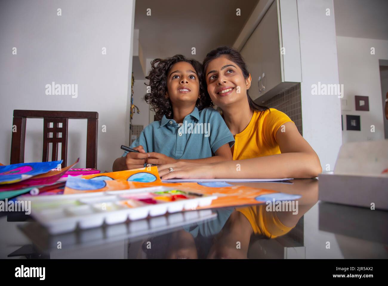 Mother and son looking above during painting Stock Photo - Alamy