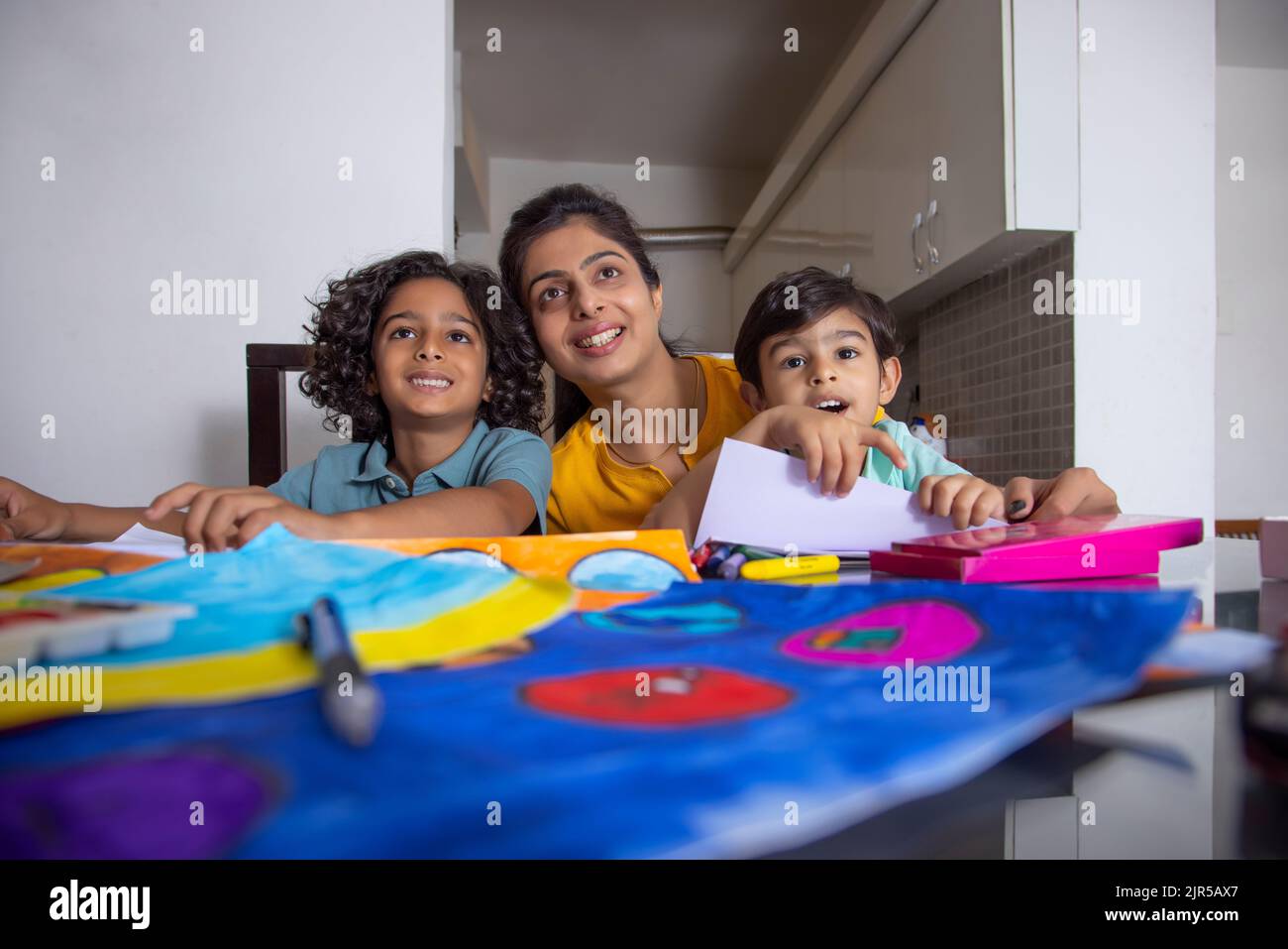 Mother and children together looking above during painting Stock Photo ...