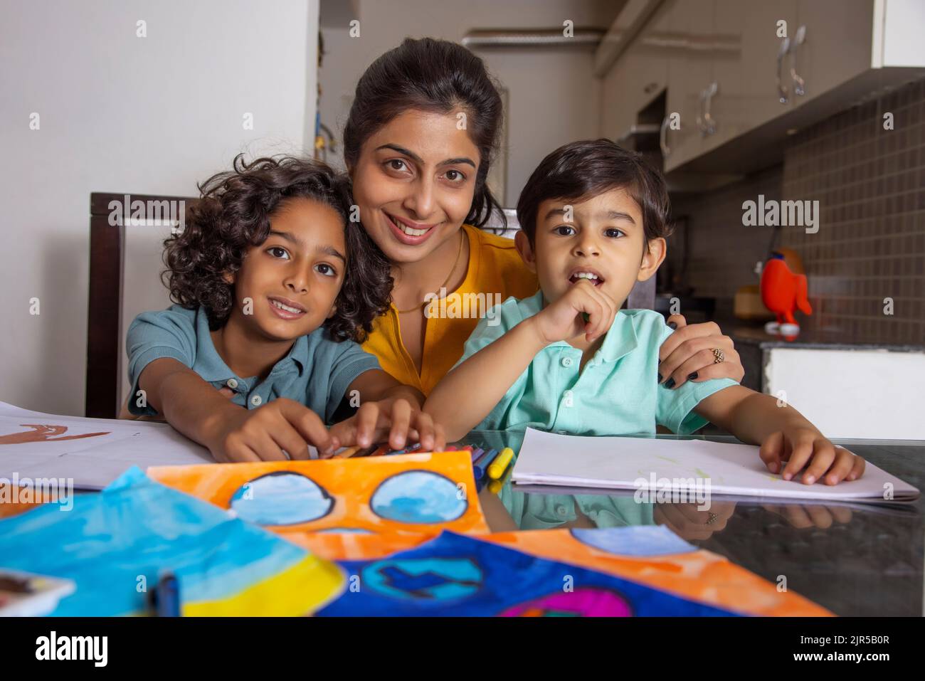 Mother with her children looking at camera during painting Stock Photo ...
