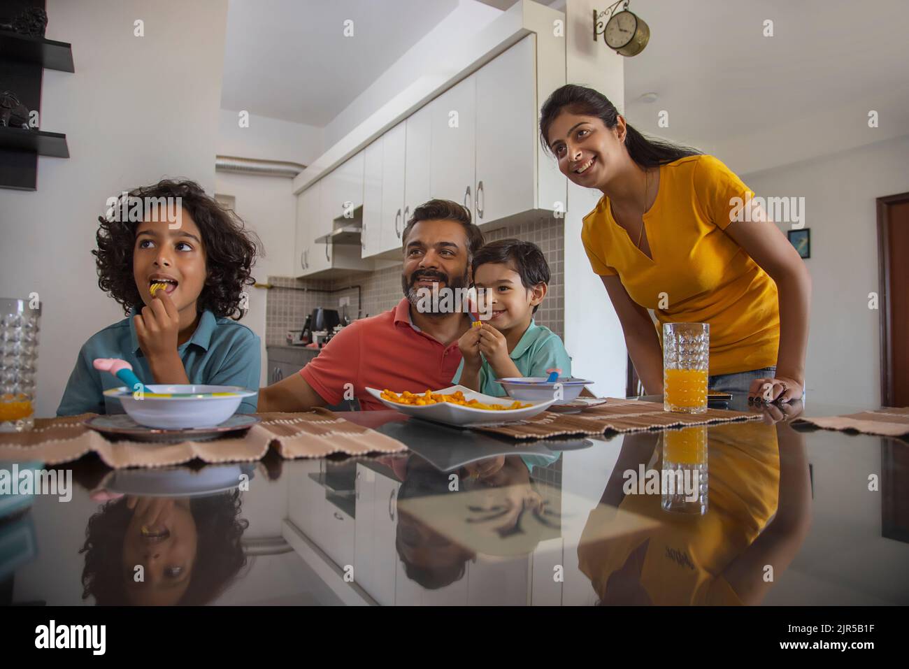 Portrait of a nuclear family looking away during breakfast Stock Photo ...