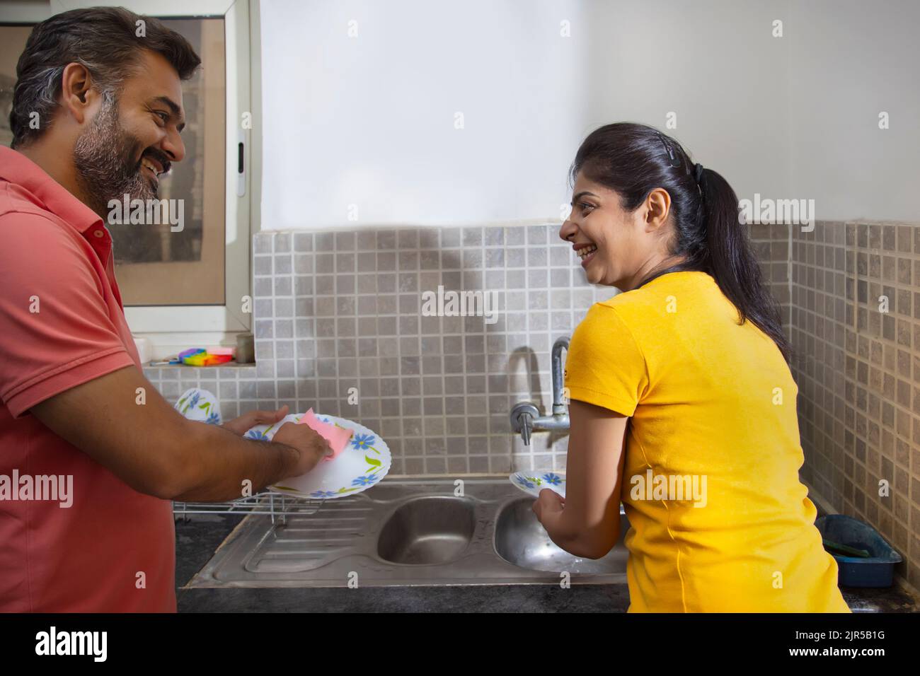 Portrait of couple washing dishes together in the kitchen Stock Photo ...