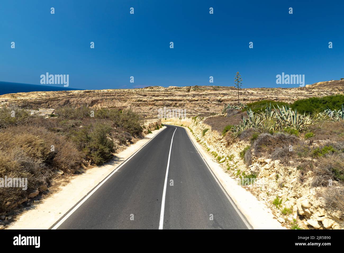 Desolated road through a desert and ghost town with wide views over a ...