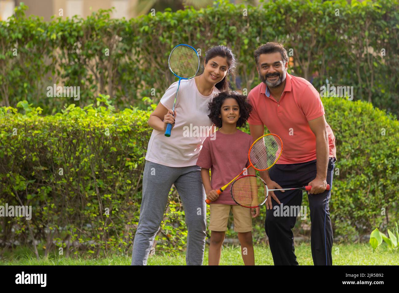 Happy parent with their child posing in front of camera with holding ...