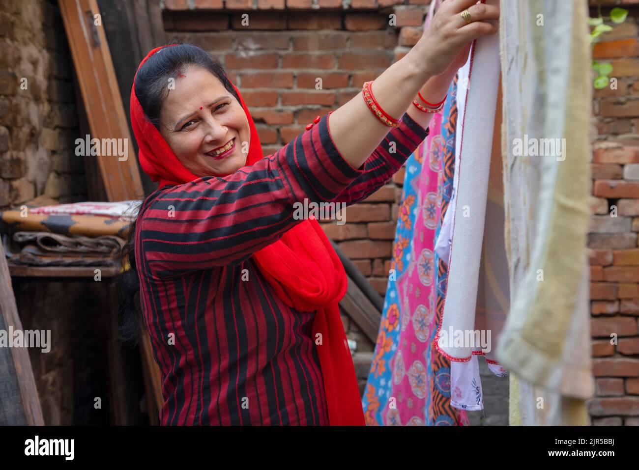 Woman hanging clothes on washing line to dry in the backyard Stock ...