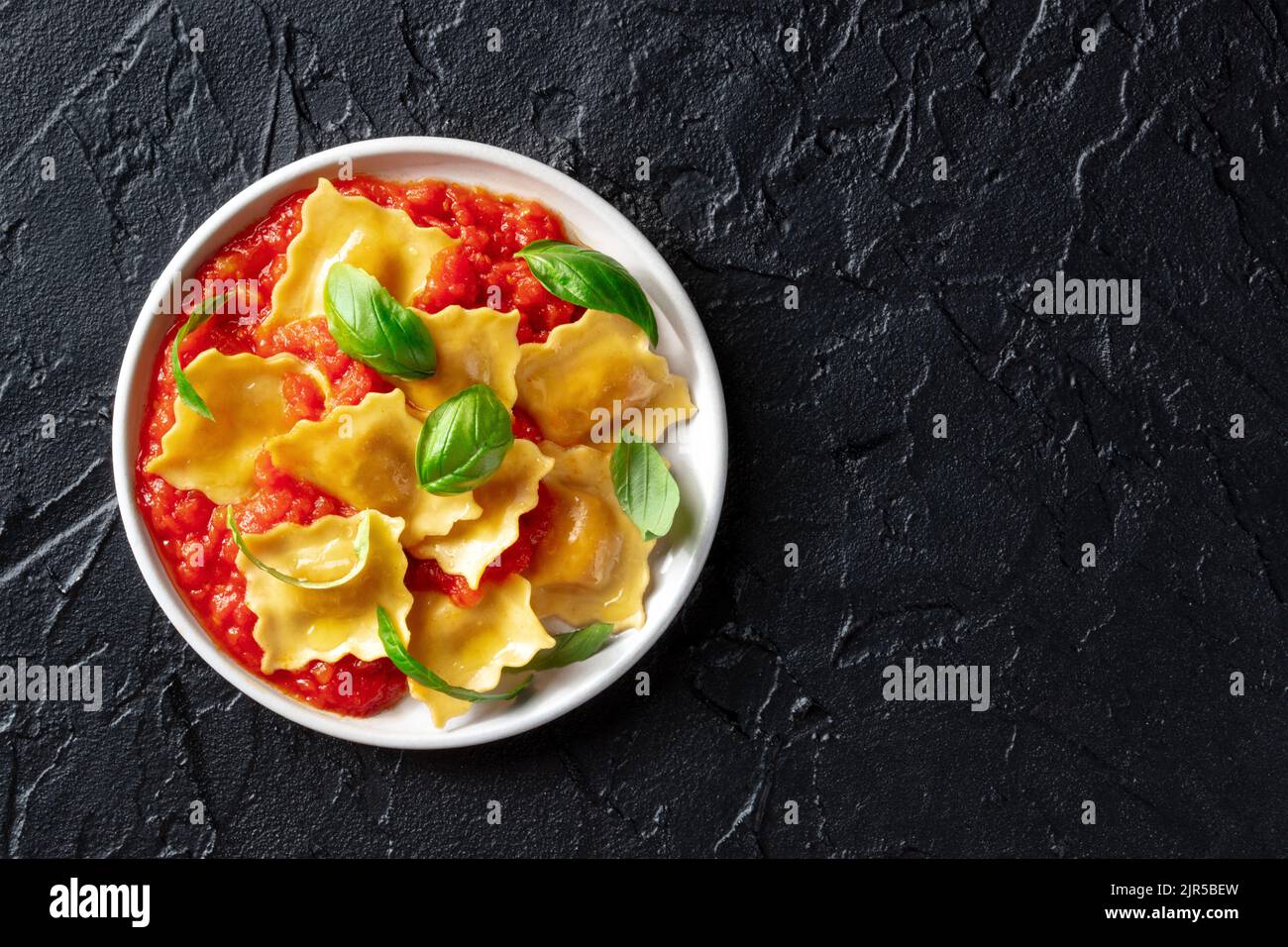 Ravioli with tomato sauce and fresh basil leaves on a plate, Italian ...