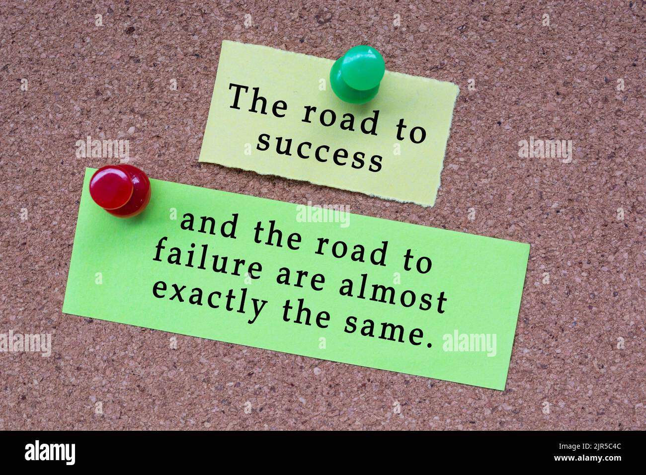 Motivational quote on stick note and pinned to a cork notice board. The ...