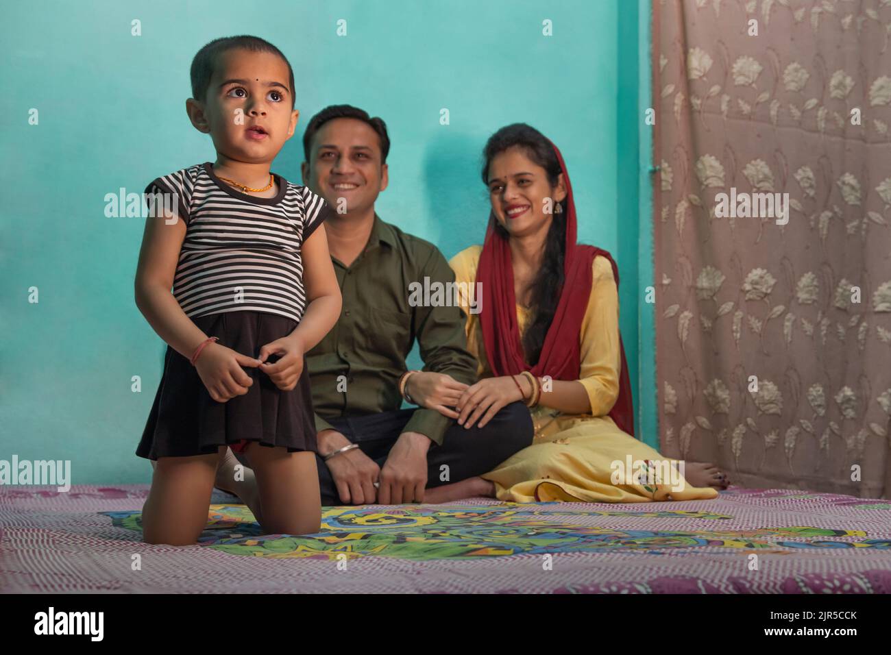 Portrait of happy parent with their child looking at camera while ...