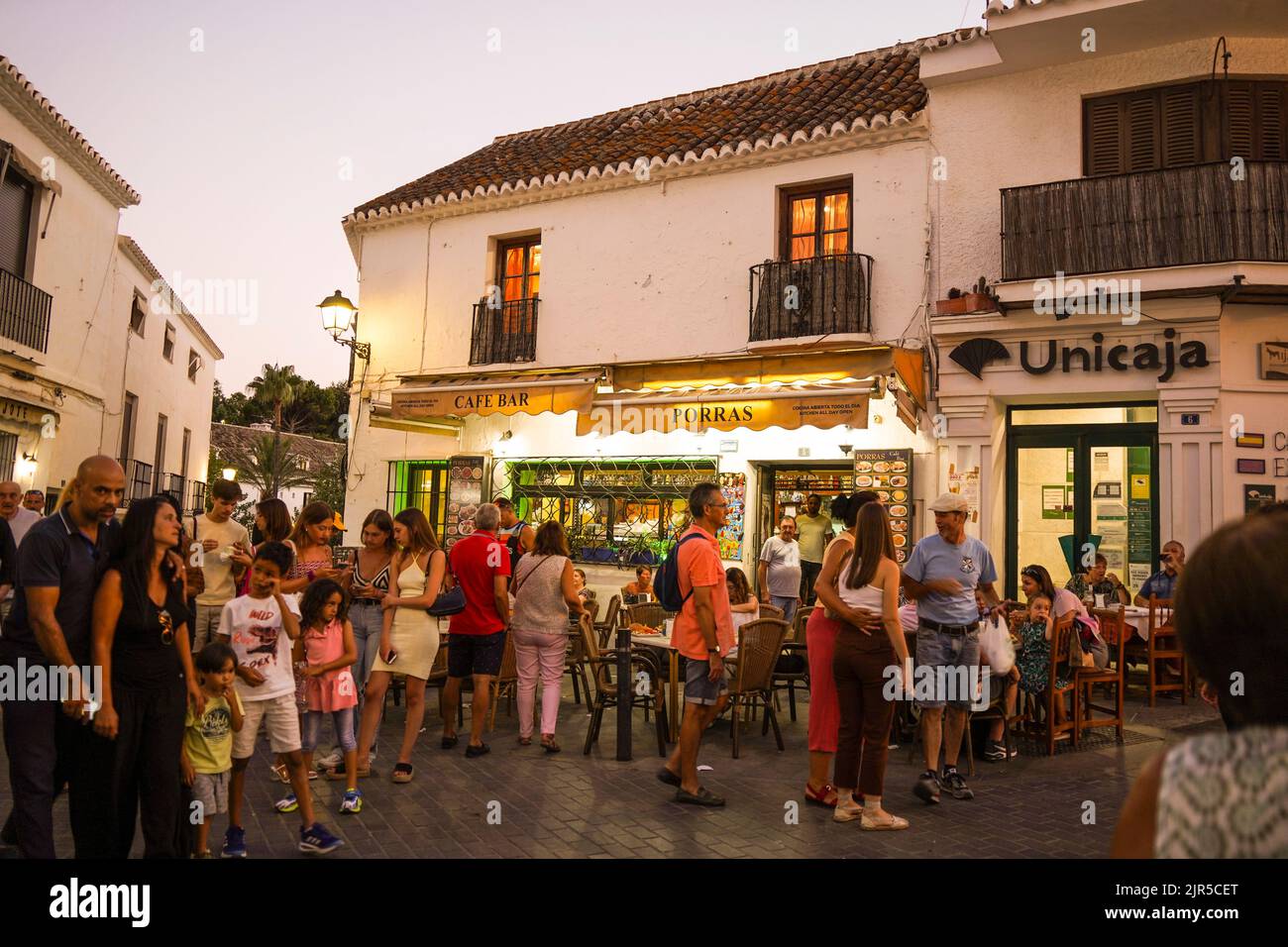 Busy summer with tourists in Spanish white village in the evening ...