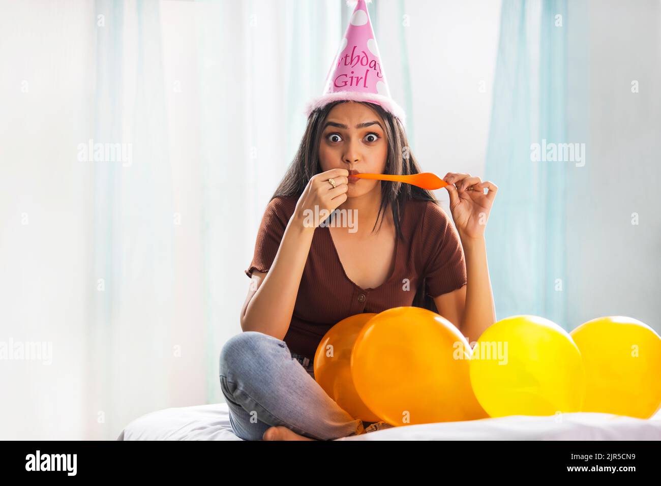 Young woman blowing up balloons hi-res stock photography and images - Alamy