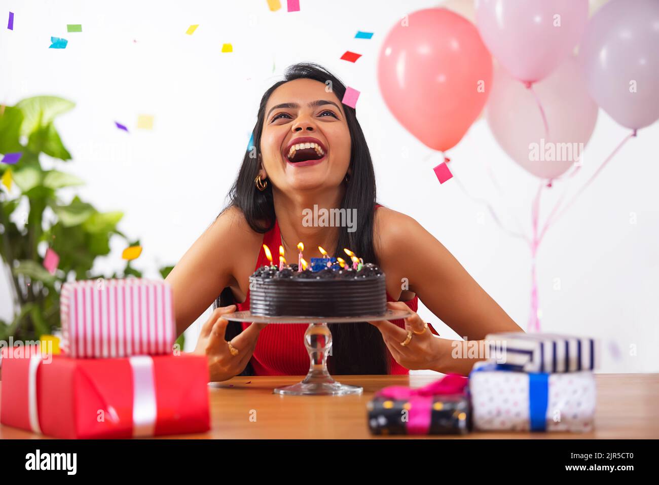 Cheerful young woman celebrating her birthday at home Stock Photo - Alamy