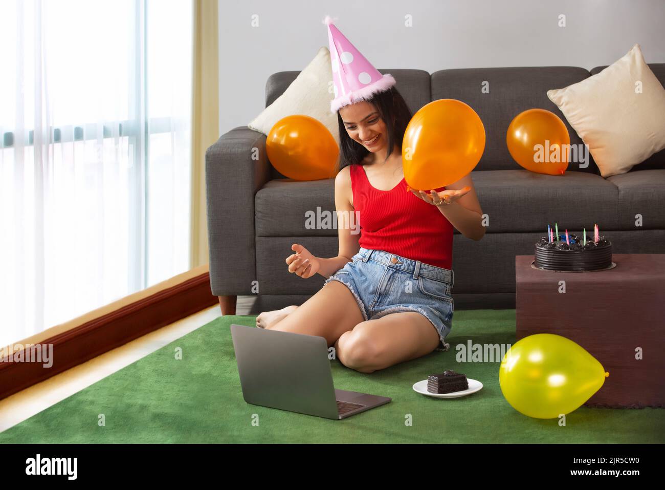 Young woman celebrating her birthday with friends virtually using ...
