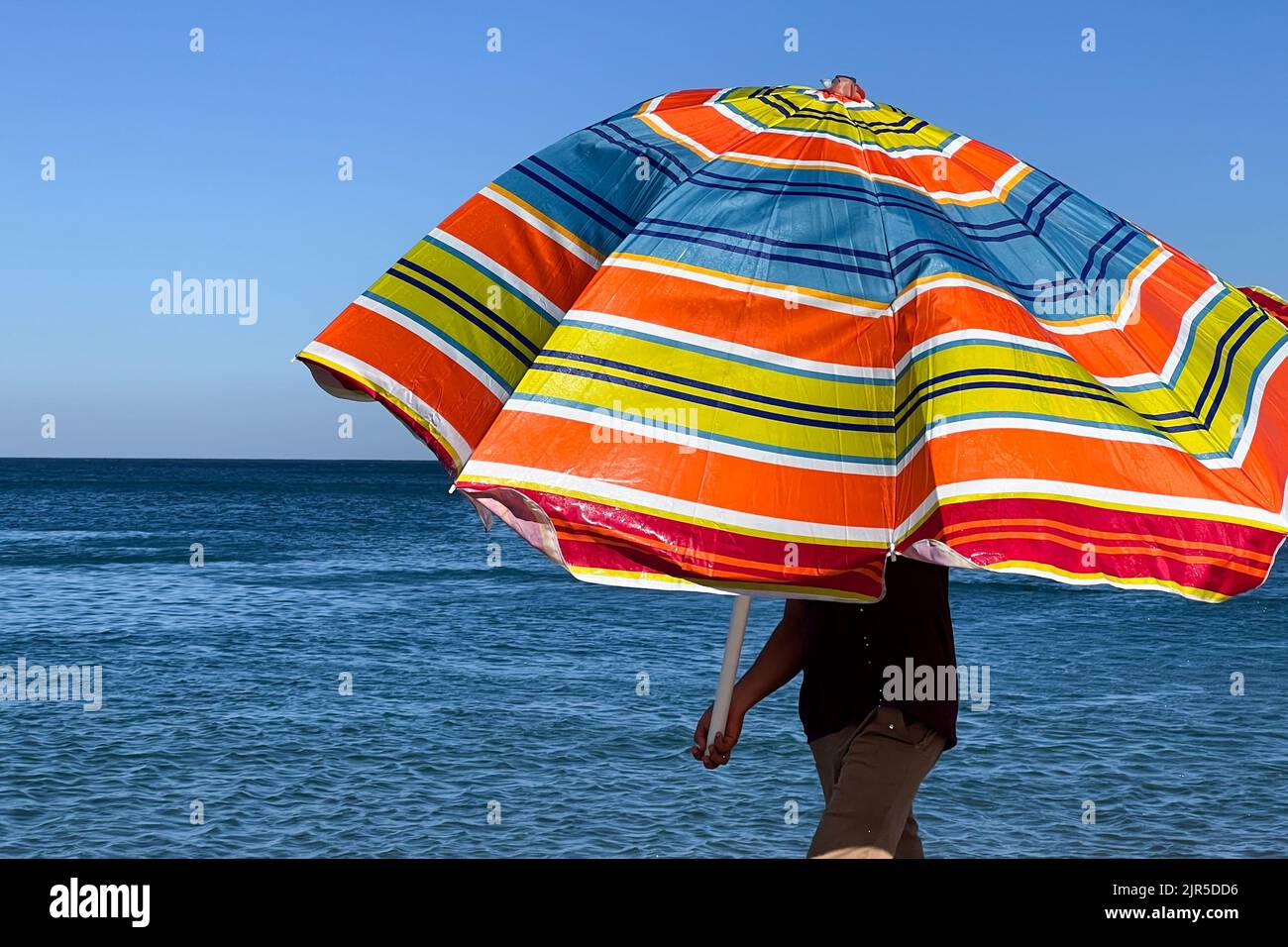 man holding an open parasol on the beach Stock Photo - Alamy