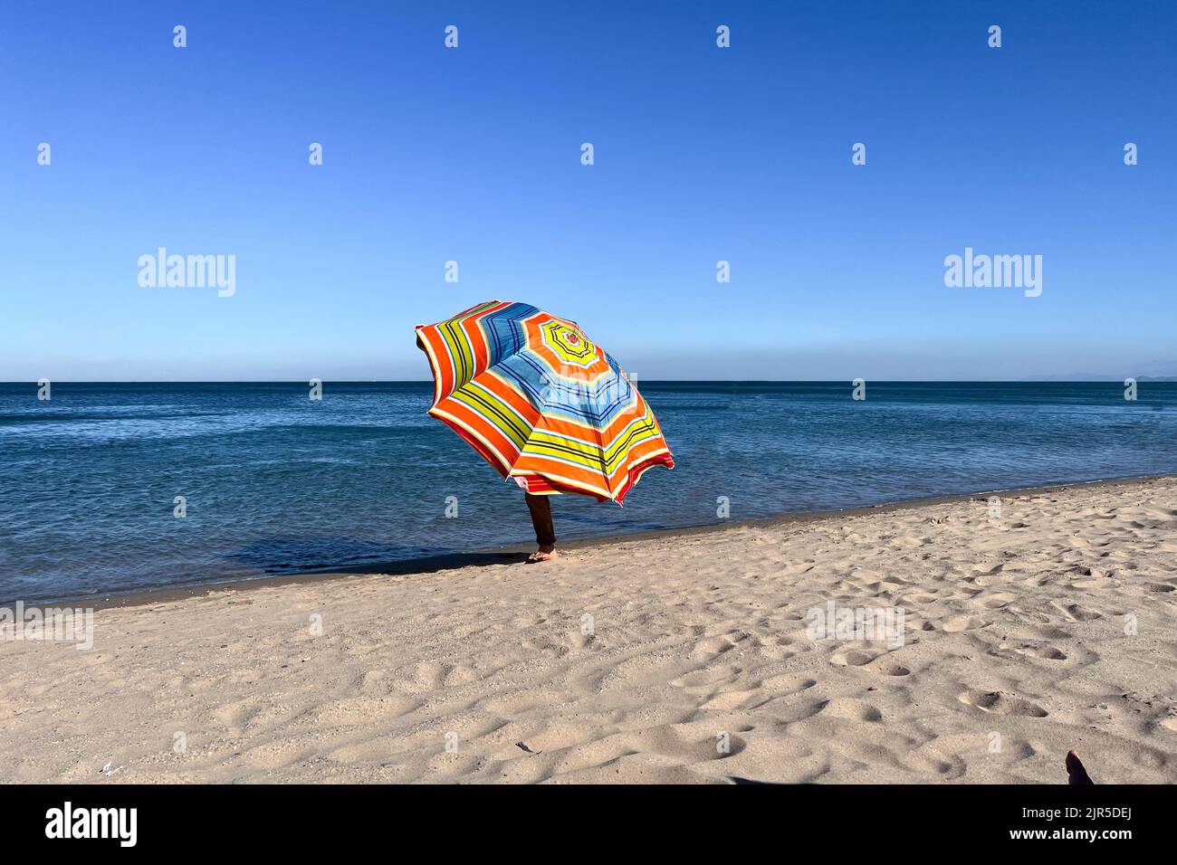 Man on beach and umbrella and windy hi-res stock photography and images ...