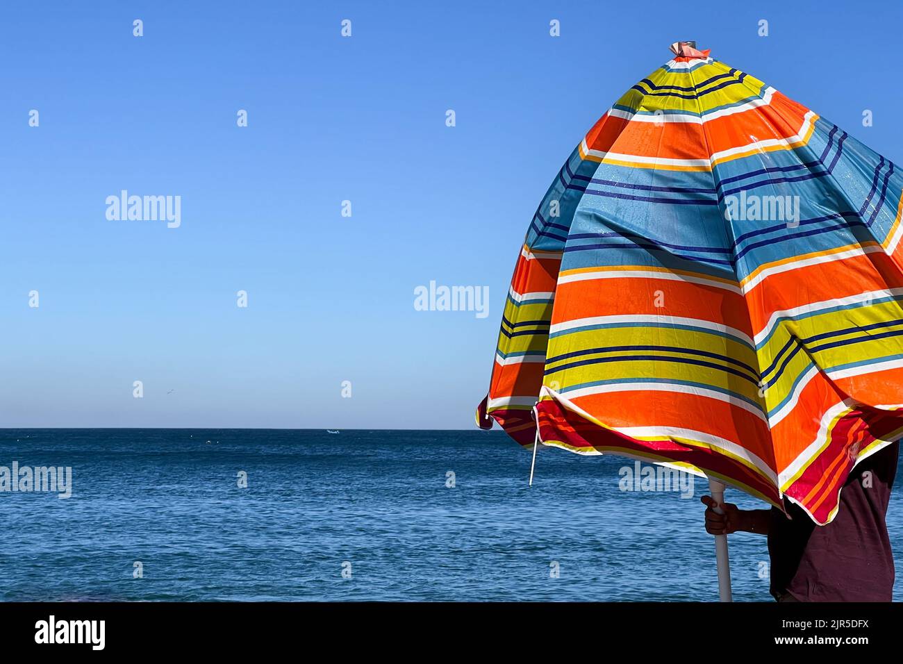 man holding an open parasol on the beach Stock Photo - Alamy