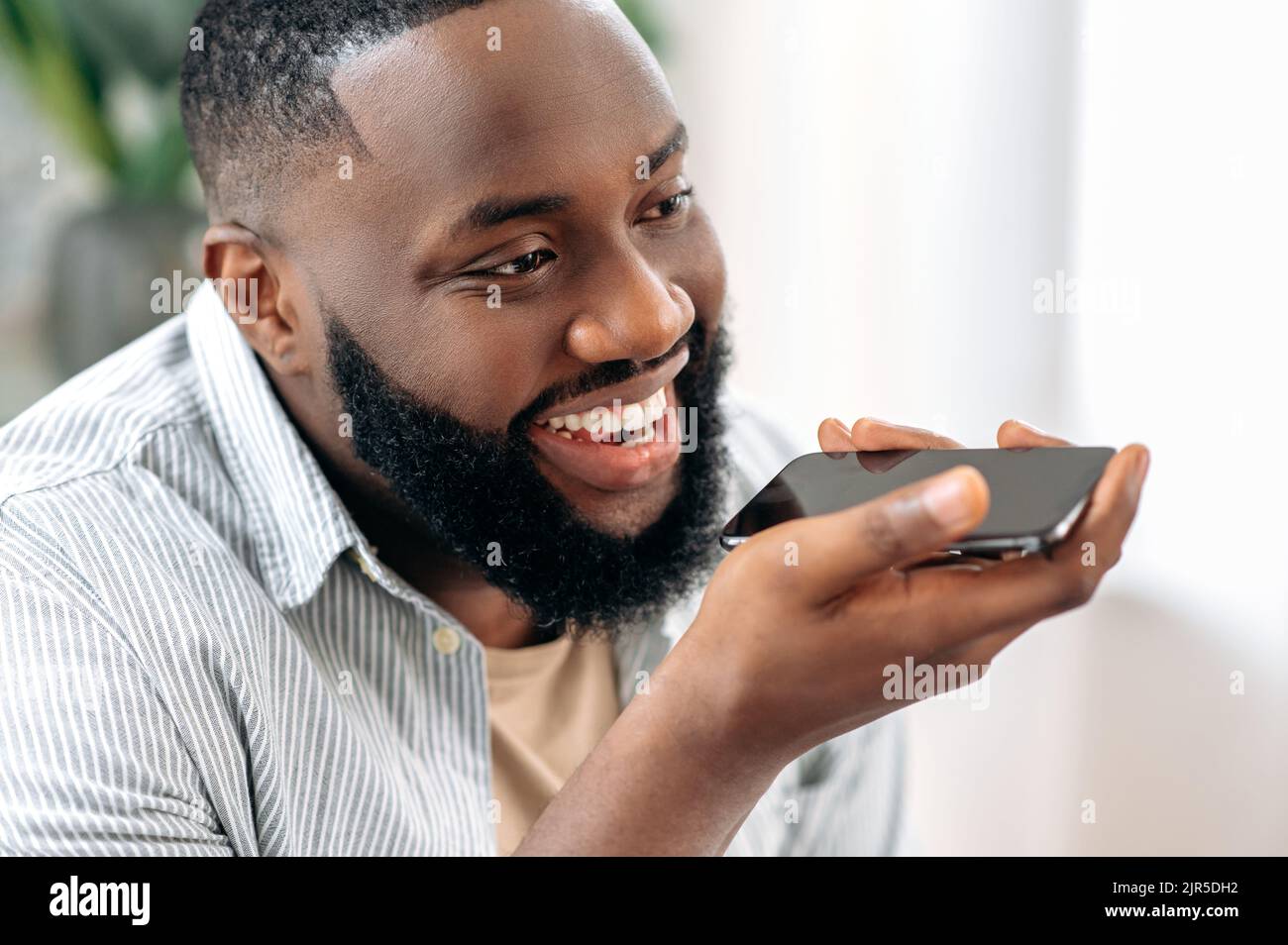 Recording a voice message. Wireless technology. Close up of a positive ...