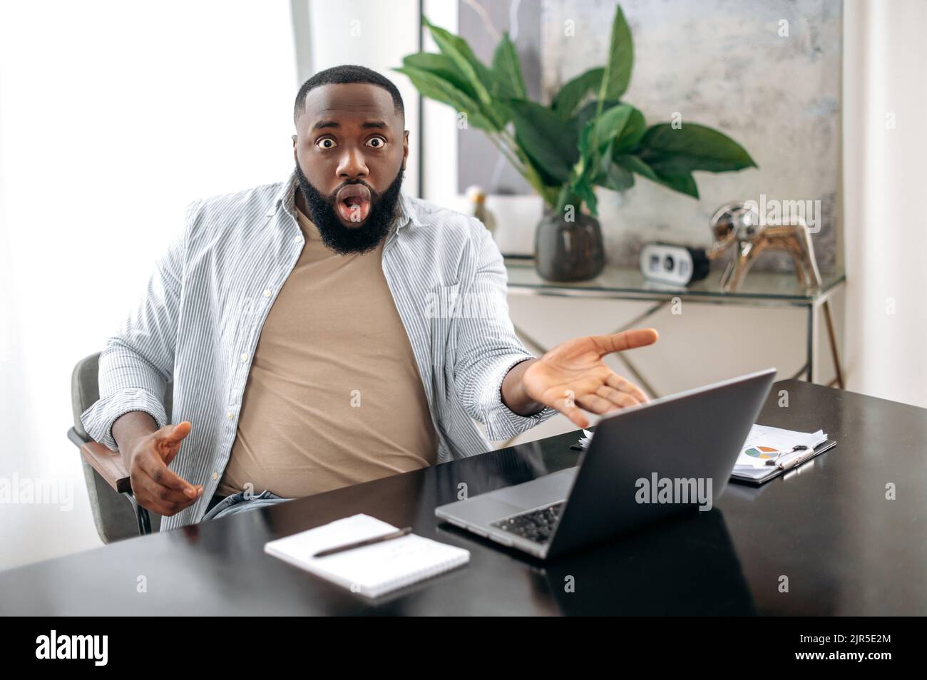 Shocked stunned African American businessman, company employee sits in ...