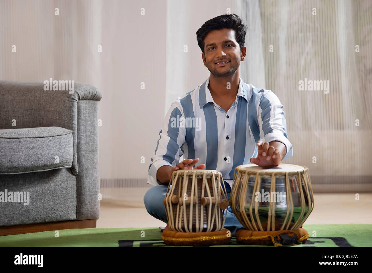 Portrait of young man playing Tabla at home Stock Photo - Alamy