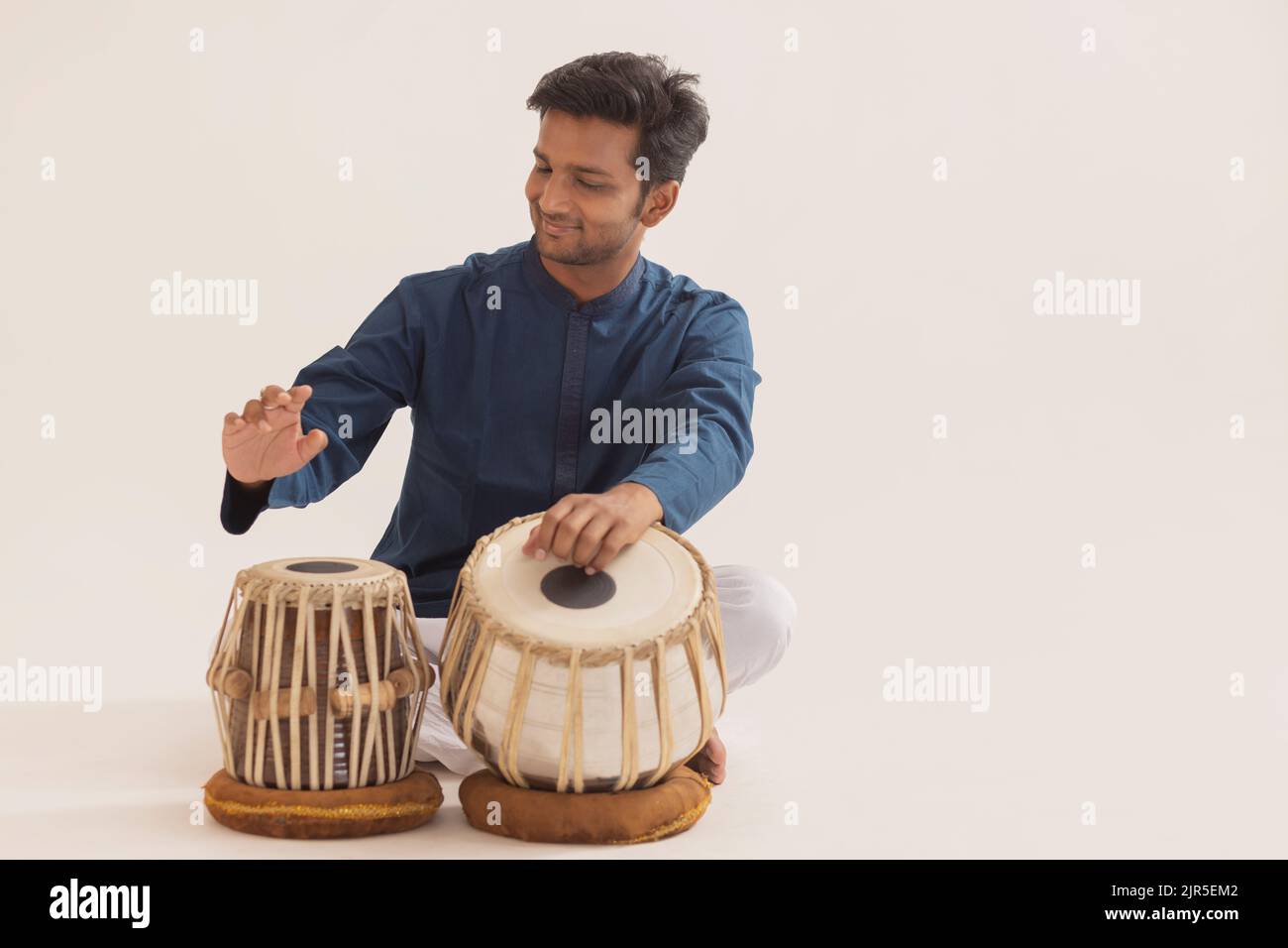 Portrait of young man playing Tabla against white background Stock ...