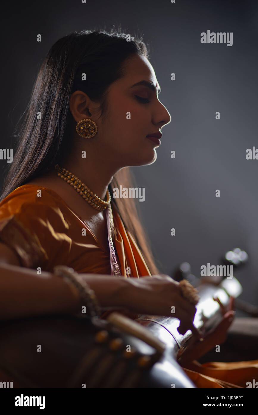 Close-up view of a female musician performing with Tanpura at concert ...