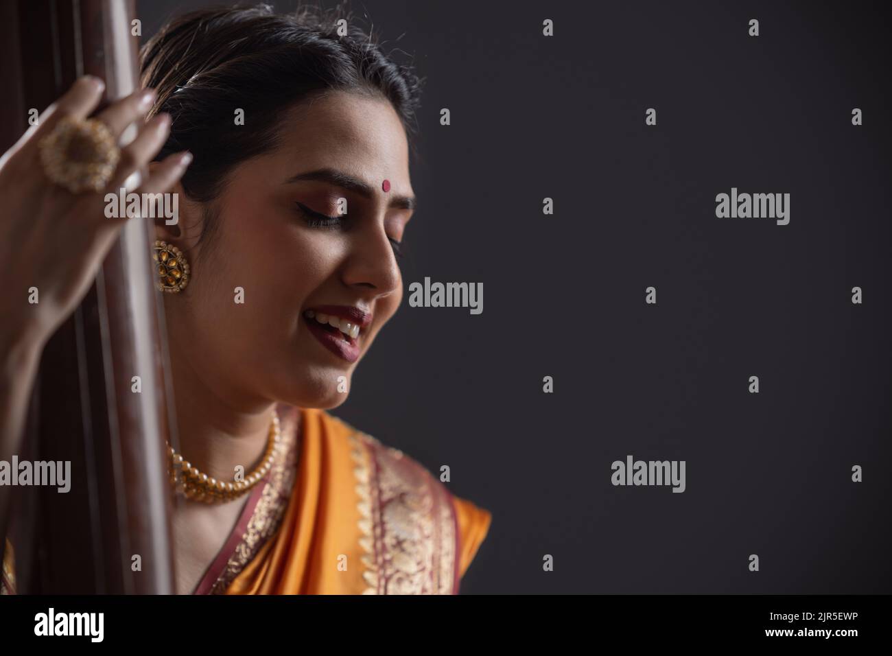 Close-up view of a female musician performing with Tanpura at concert ...