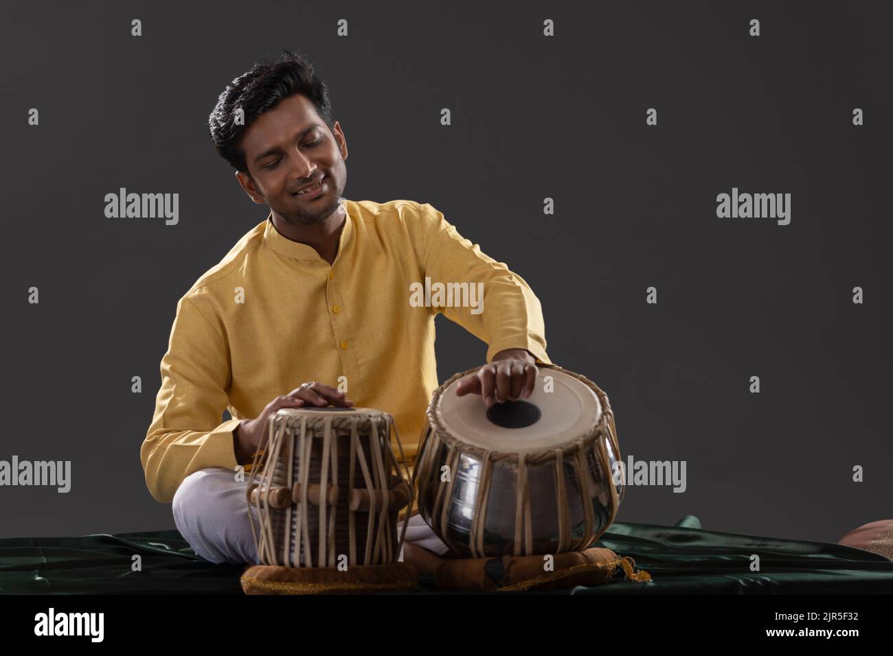 Portrait of young man performing with Tabla on stage Stock Photo - Alamy
