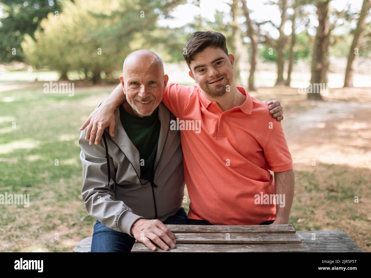 Happy senior father with his young son with Down syndrome embracing and ...