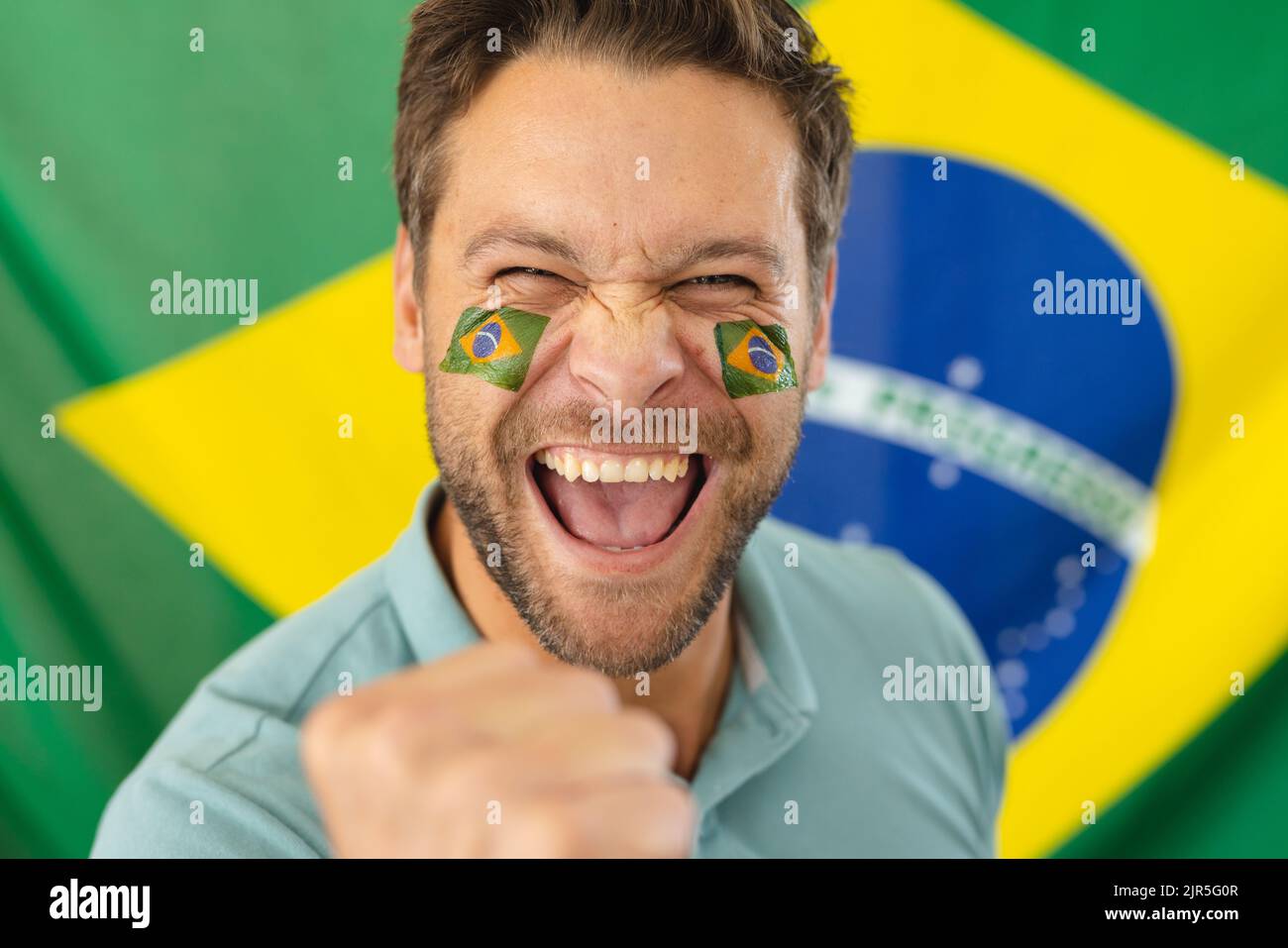 Image of happy caucasian man with flags of brazil on face over flag of ...