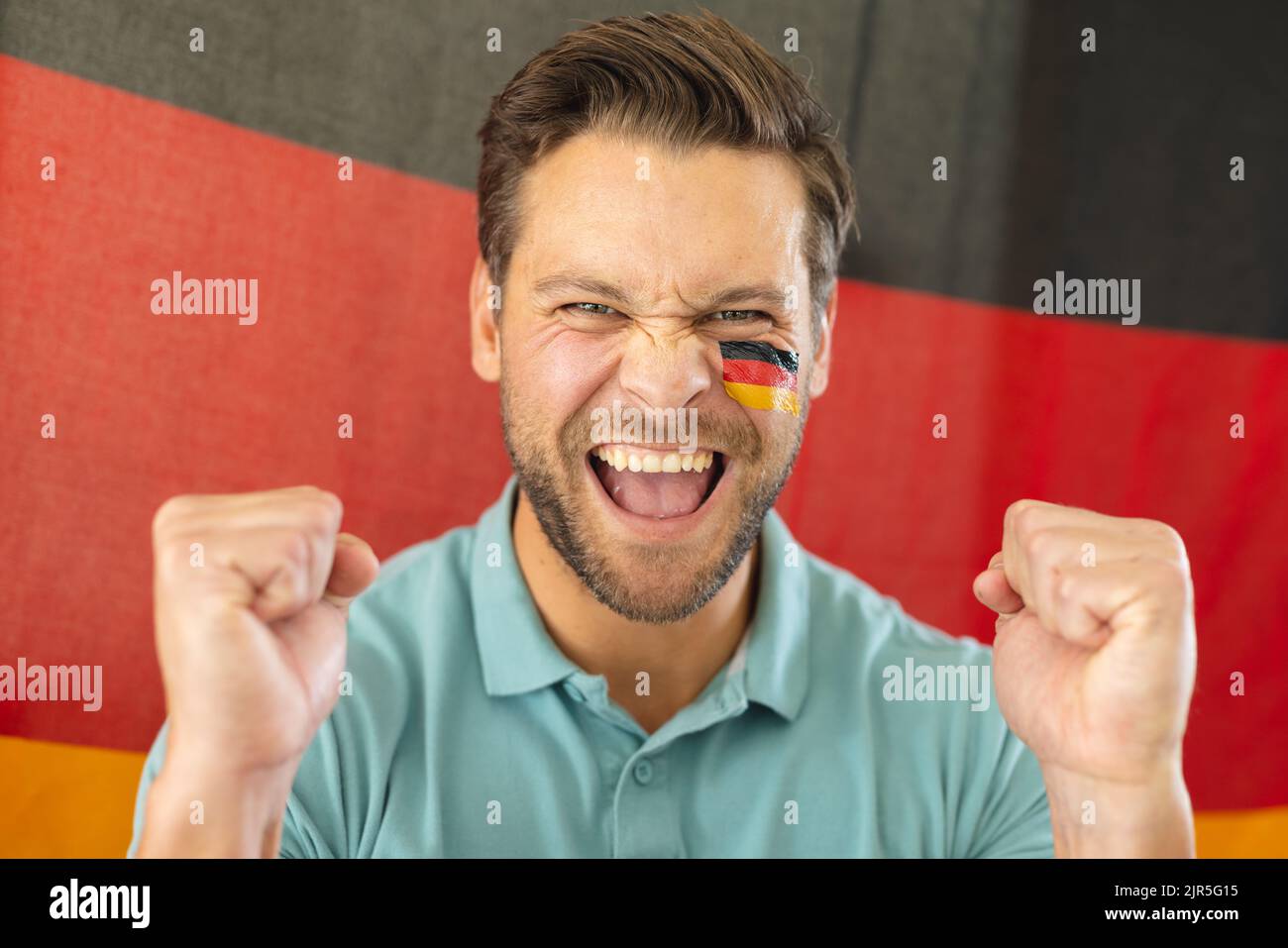 Image of happy caucasian man with flags of germany on face over flag of ...