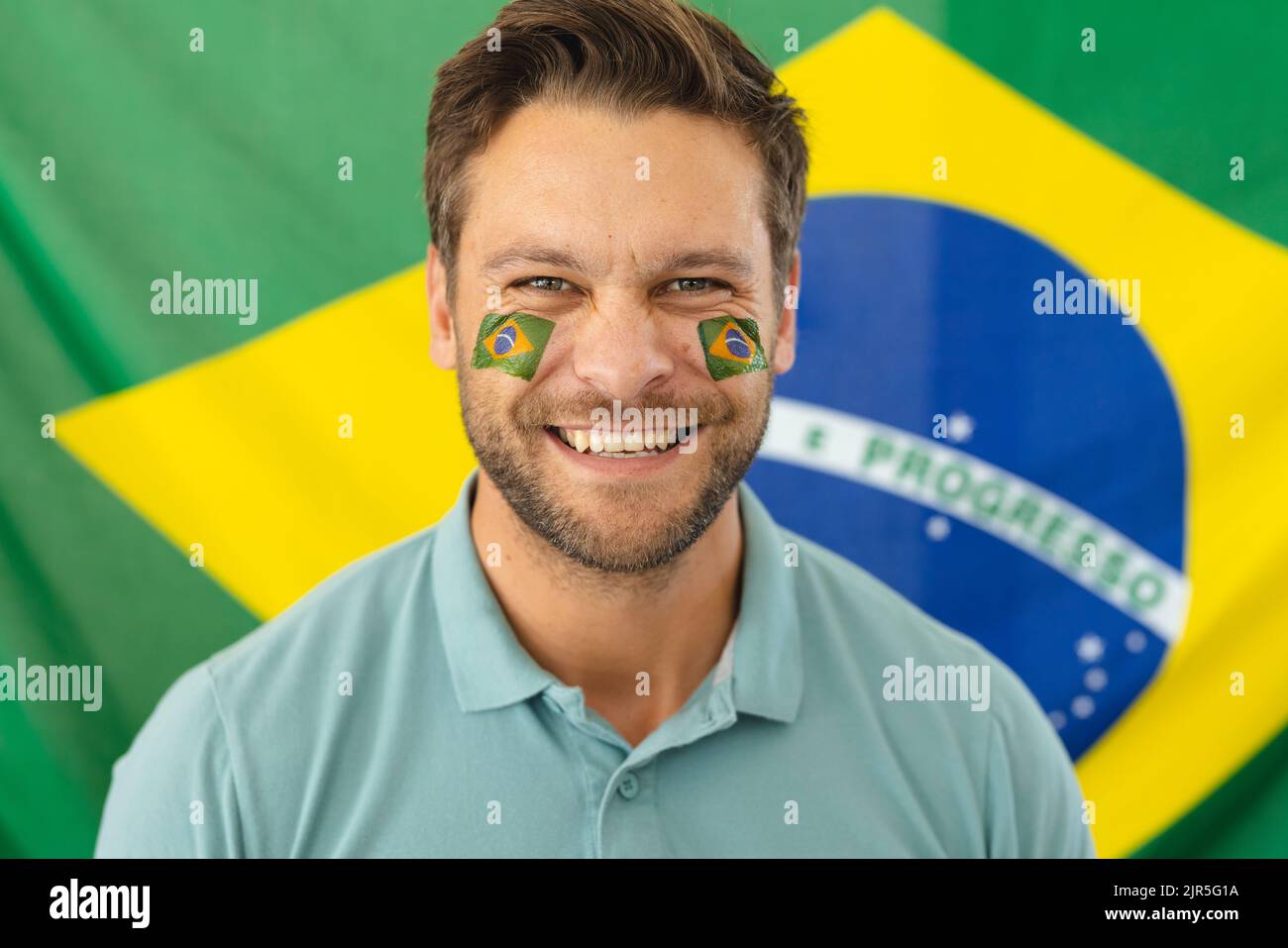 Image of happy caucasian man with flags of brazil on face over flag of ...