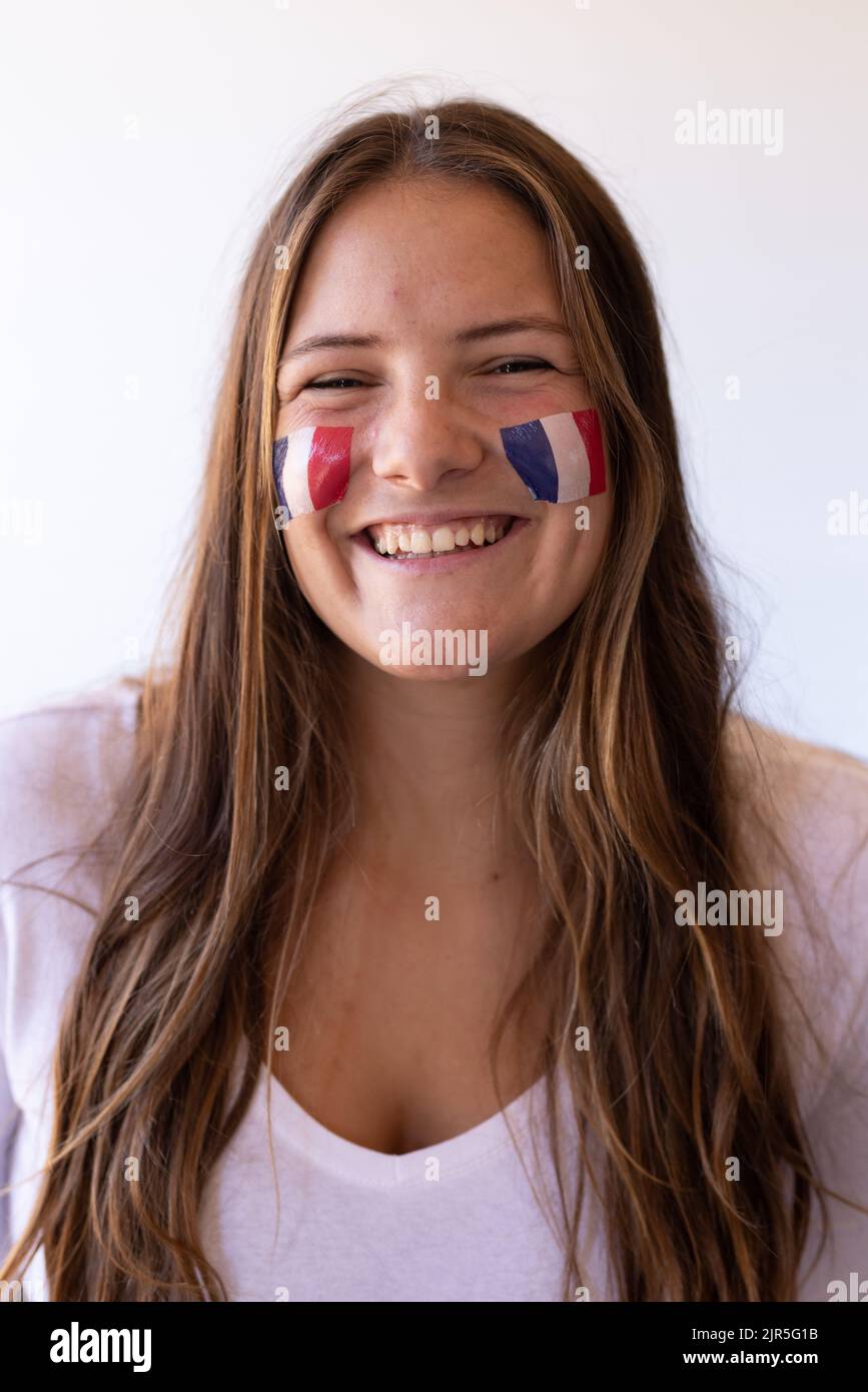 Vertical image of happy caucasian woman with flags of france on face ...