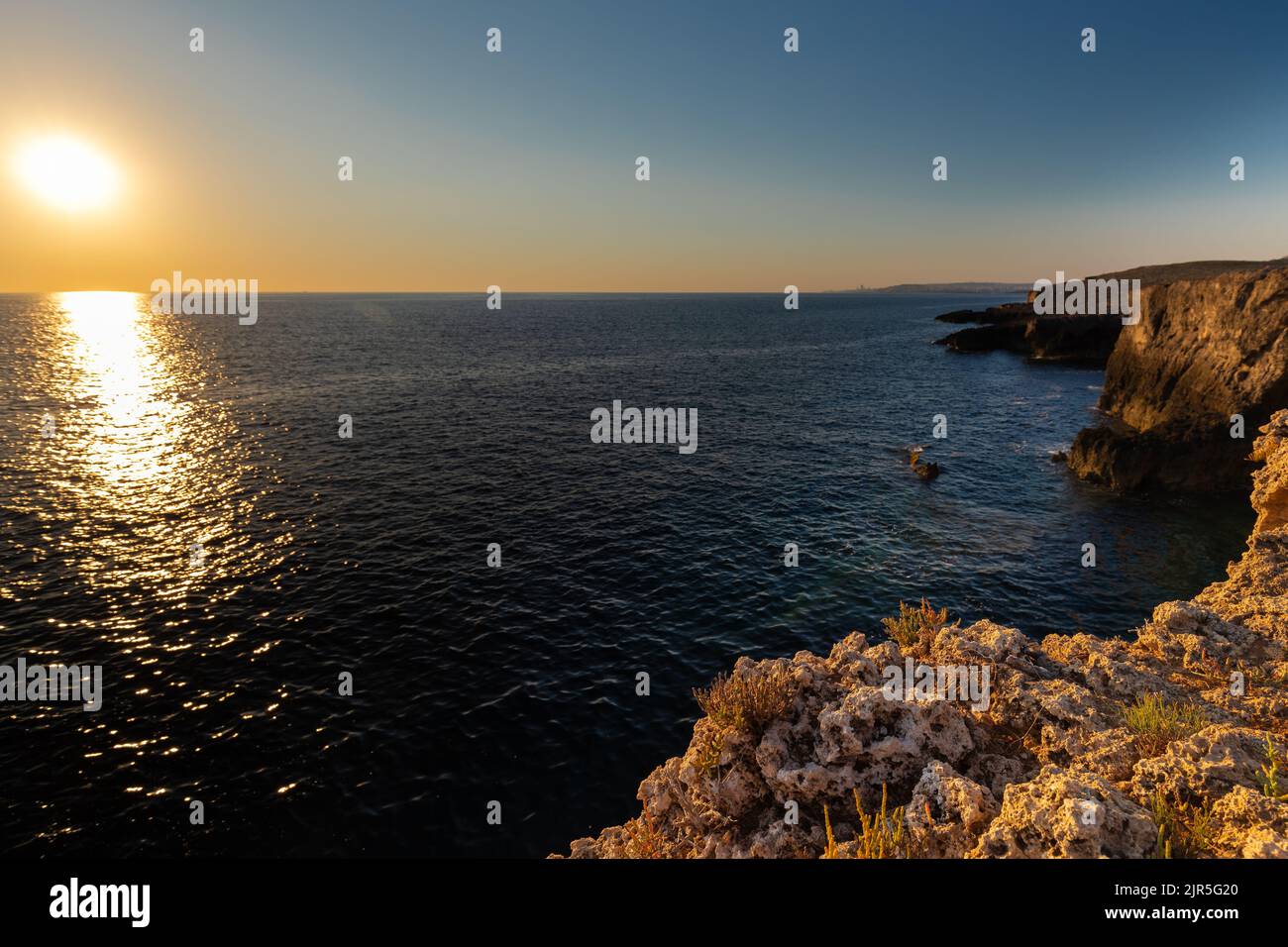 Amazing sunrise over the rising cliffs and rocks in Malta, with ...