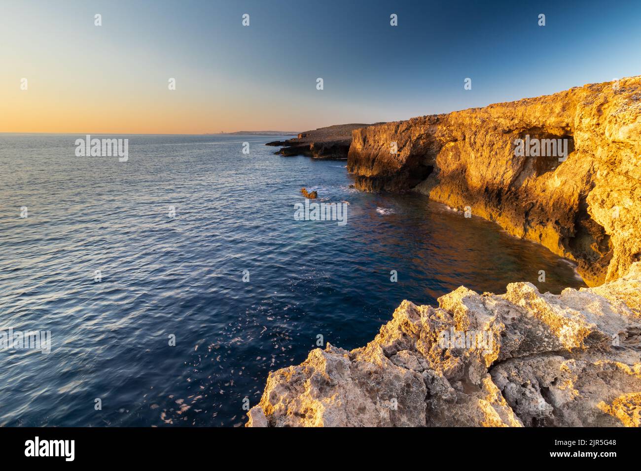Amazing sunrise over the rising cliffs and rocks in Malta, with ...