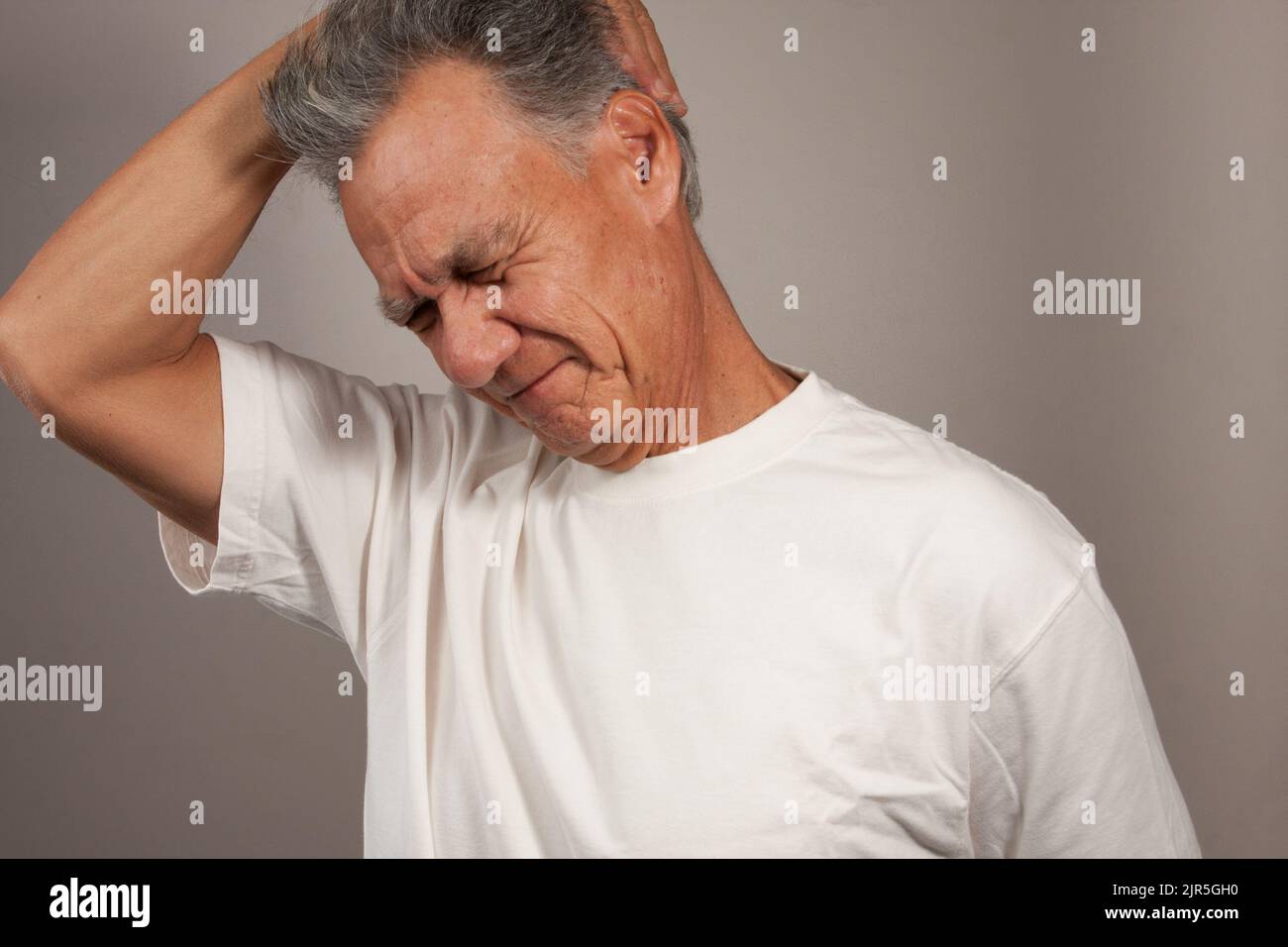 Mature Man 60plus doing back of the neck stretches for back and neck ...